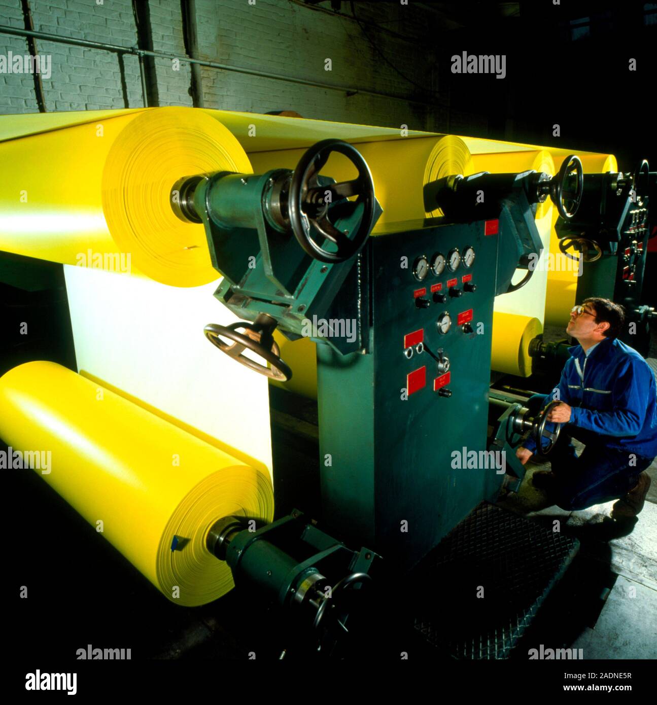 Paper coating. View of a technician monitoring part of the paper ...