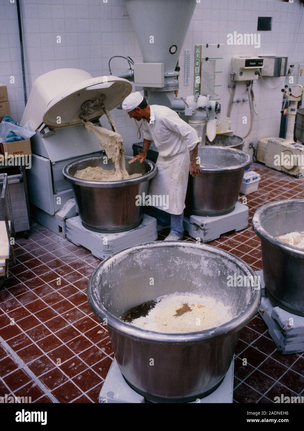 MODEL RELEASED. Bakery. Baker mixing bread dough in an industrial-sized ...
