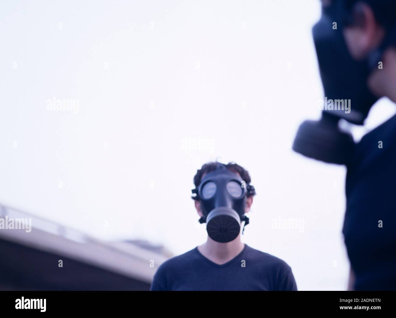 Gas masks. Two men wearing respirators out in the open. This could ...