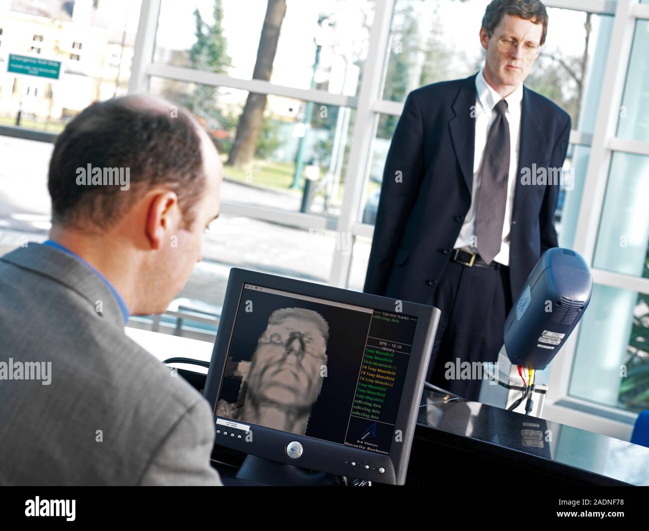 Biometric face scanning. Man (top right) having his face screened by a ...