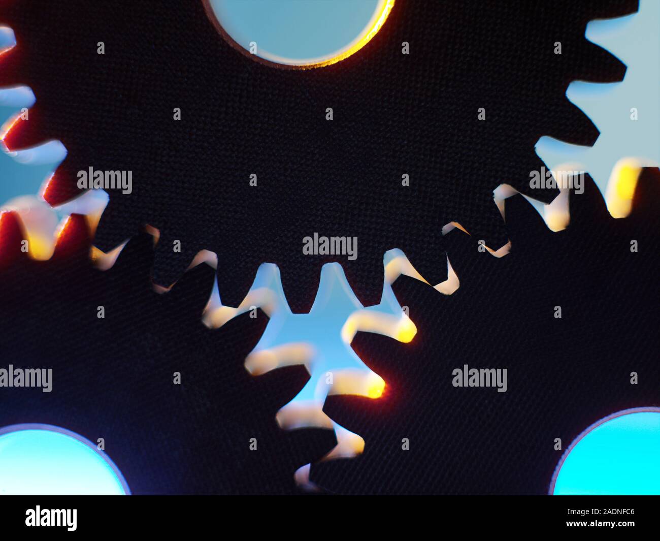 Cogs. Interlocking teeth on three cogwheels. Cogwheels transmit ...