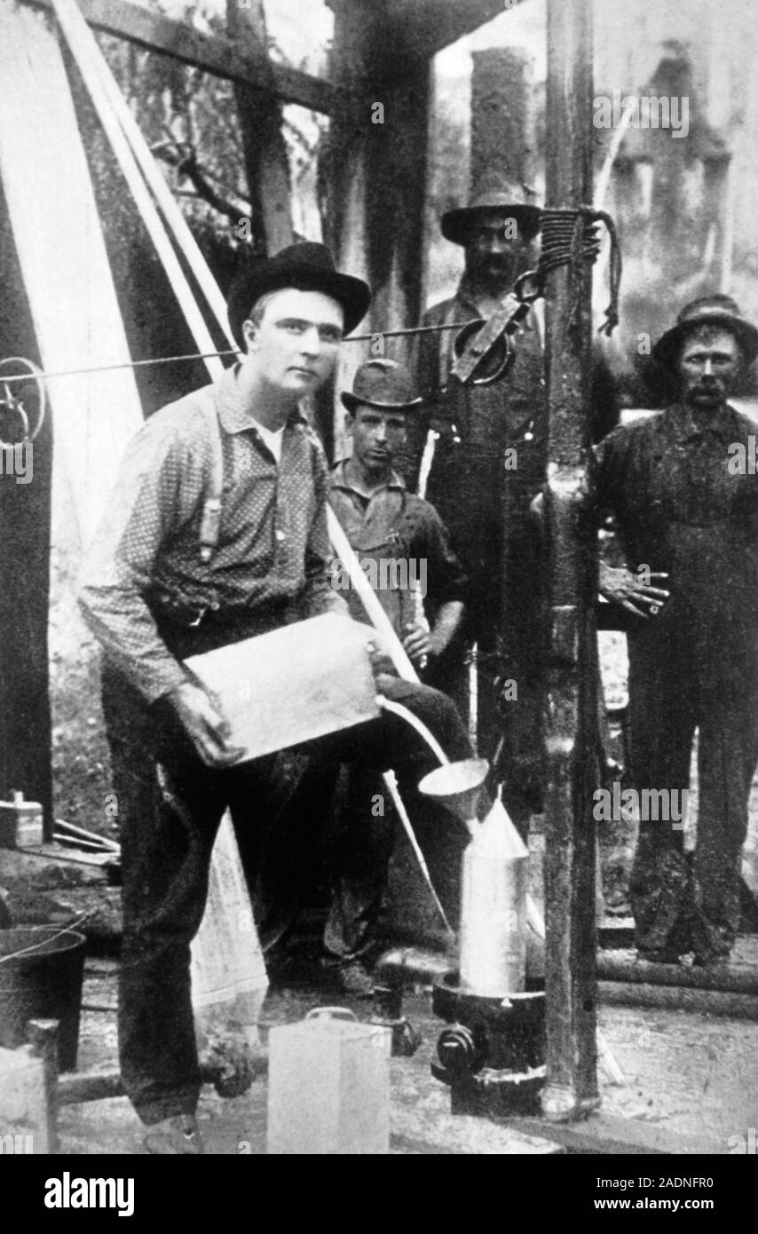 Early oil well. View of workers at an early oil well. In the foreground ...