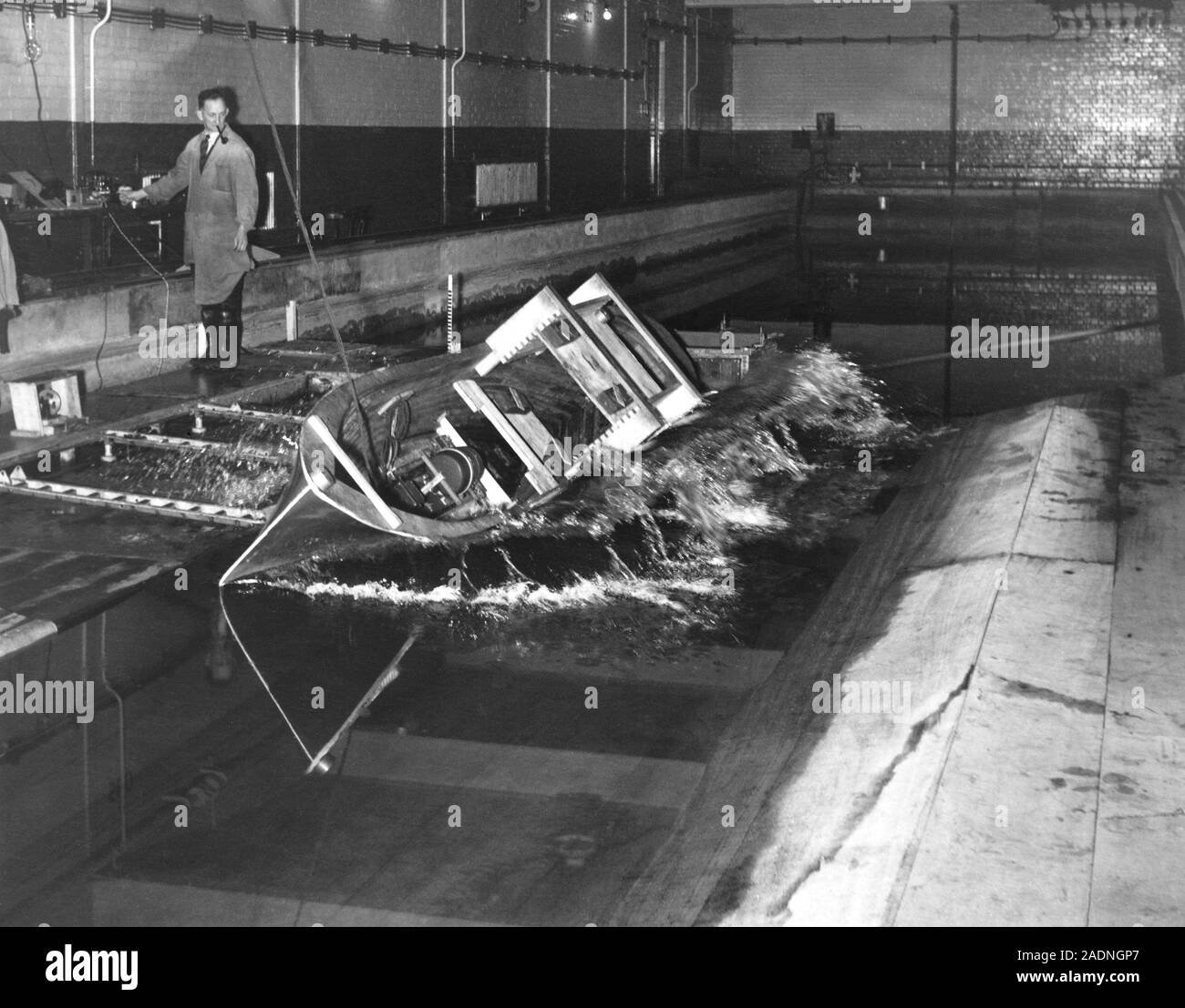 Model ship testing. Researcher observing the sideways launch of a model ...