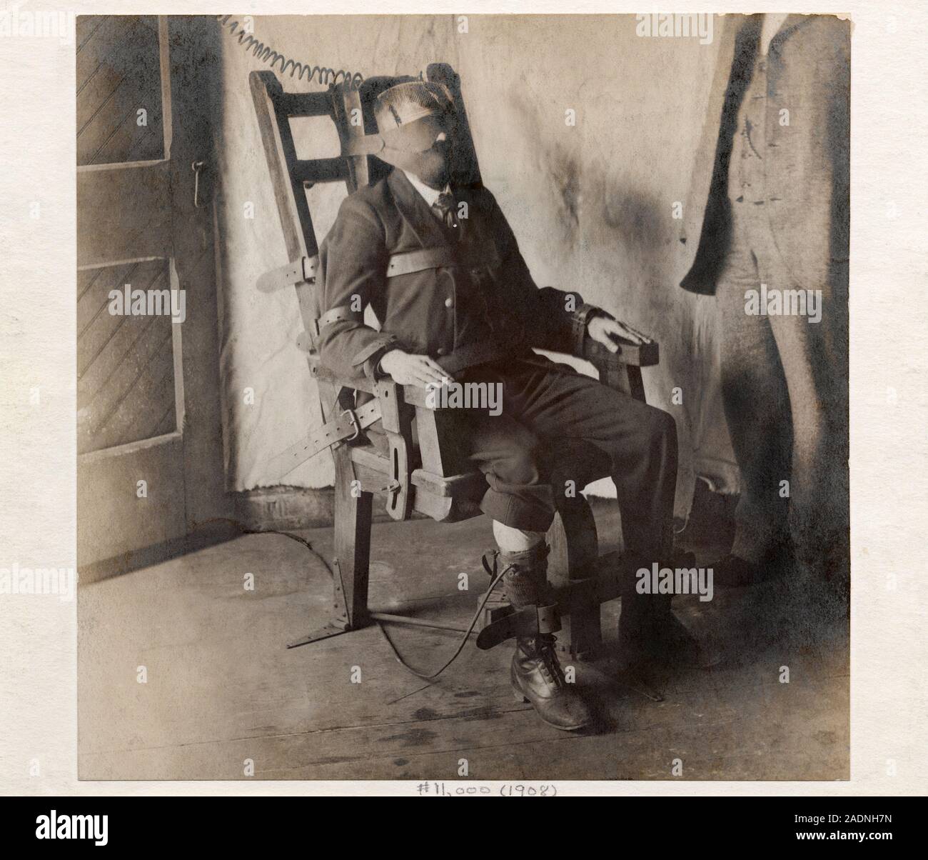 Electric chair. Historical photograph (dated 1908) of a man about to be ...