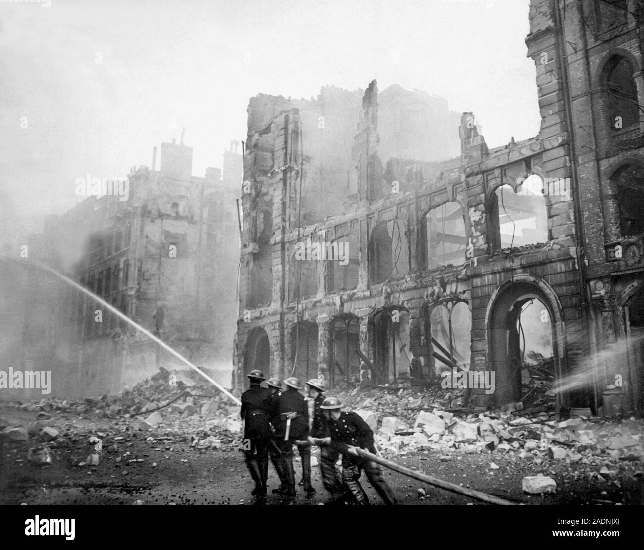 WWII air raid damage. Firemen extinguishing fires in bombed out ...