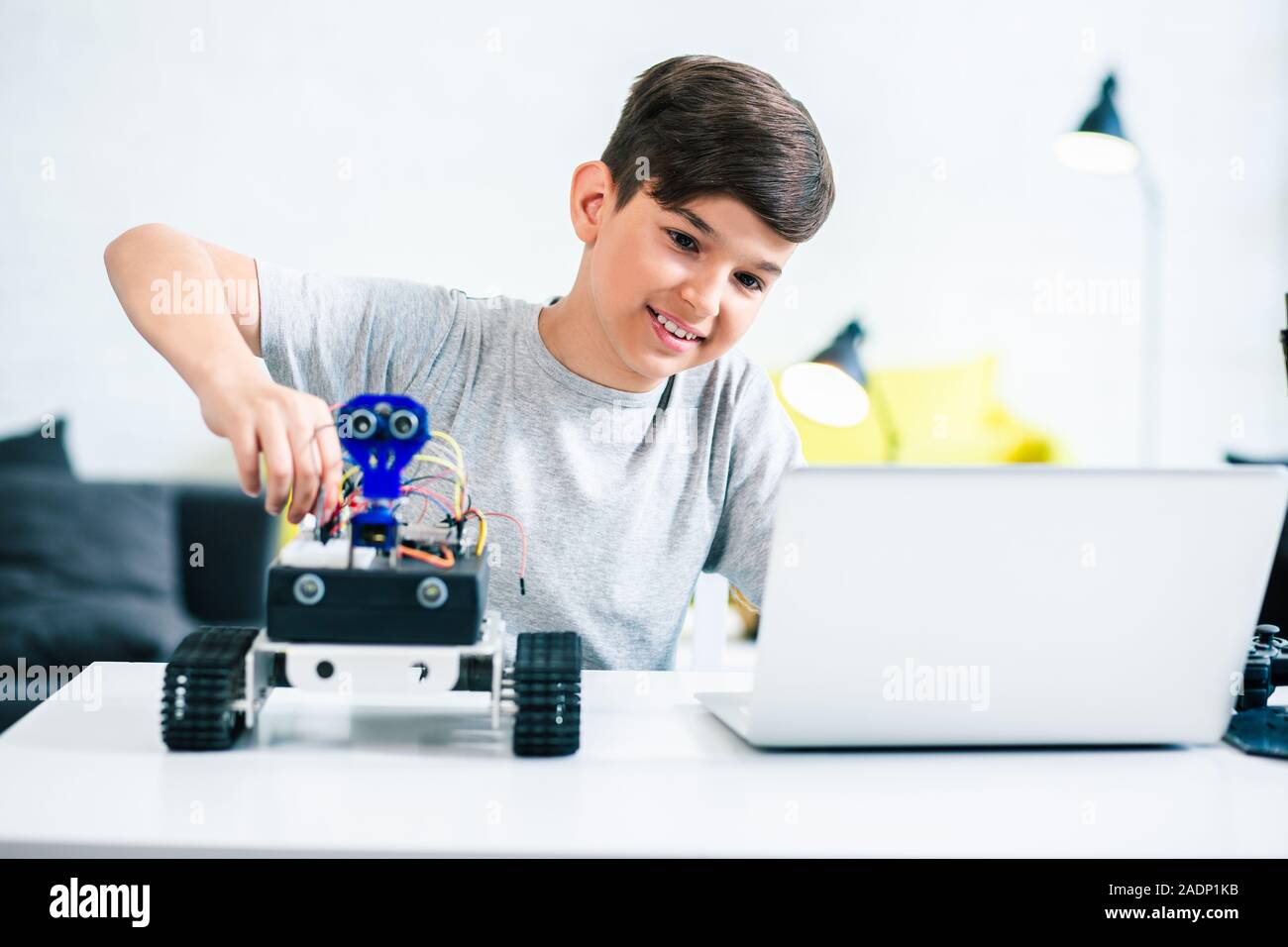 Joyful little boy constructing modern robot at home Stock Photo - Alamy