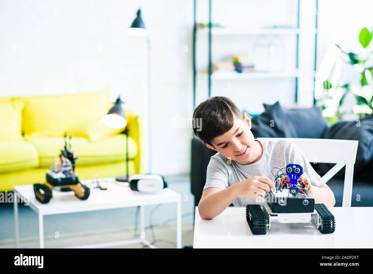 Ingenious smart boy adjusting his robotic device at home Stock Photo ...
