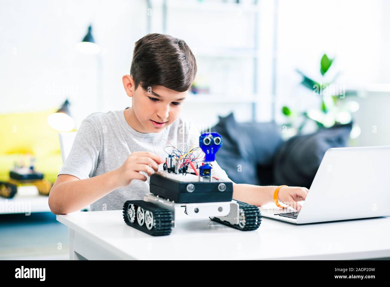 Pleasant little boy constructing robotic device at home Stock Photo - Alamy