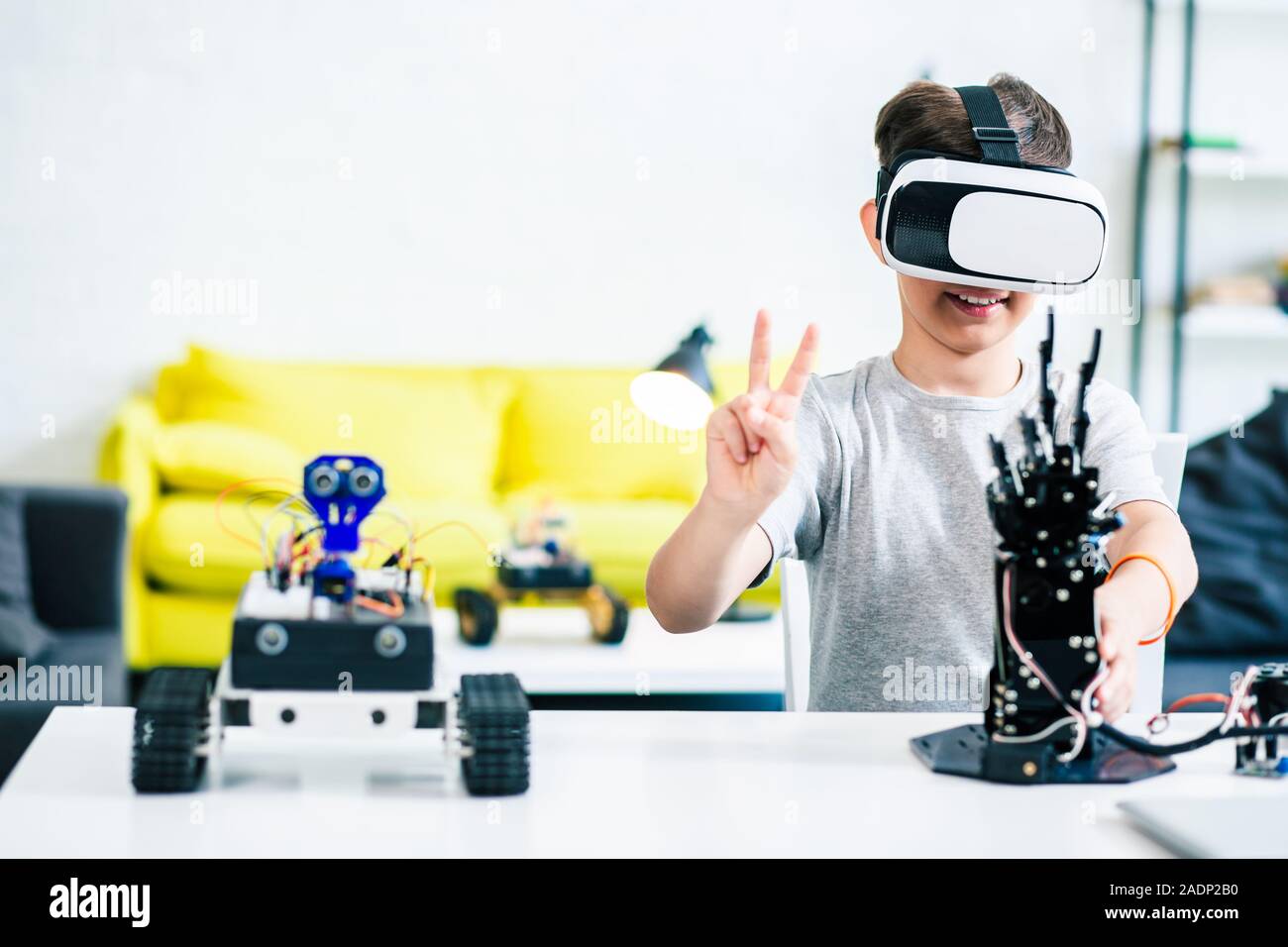 Waist up of a cheerful smart boy testing his engineering creations ...