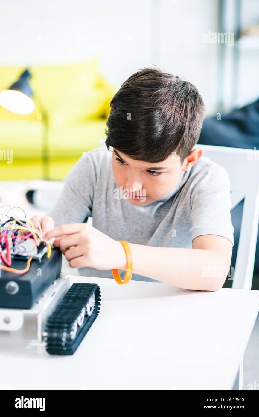 Concentrated little boy constructing a robotic device attentively Stock ...