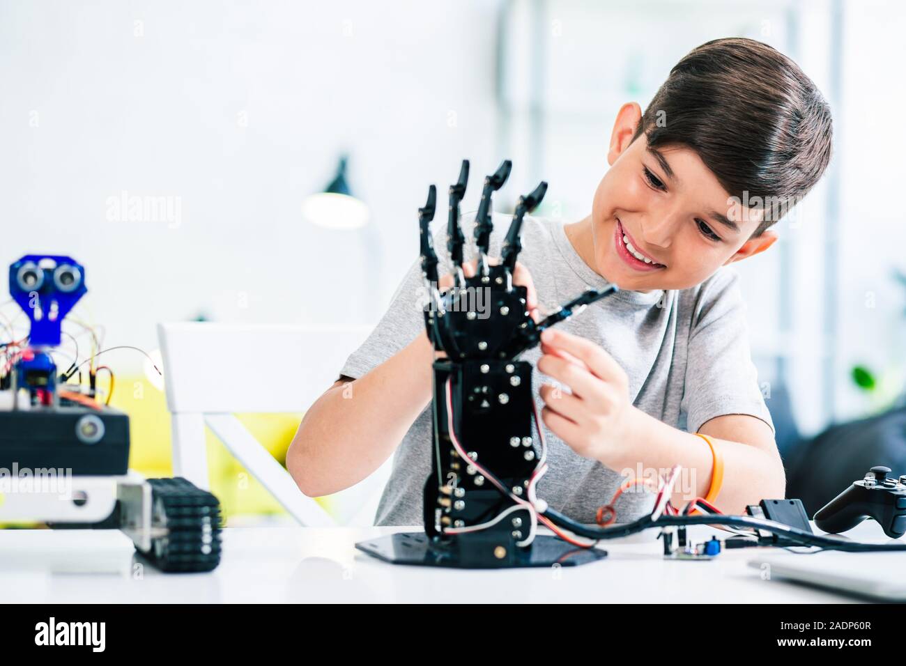Joyful smart boy constructing a robotic humanoid hand Stock Photo - Alamy