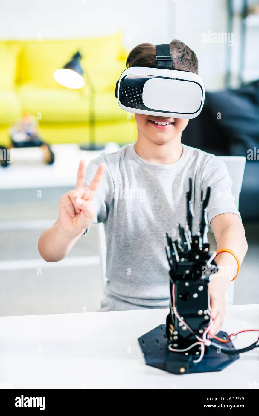 Joyful little boy testing a robotic humanoid hand Stock Photo - Alamy