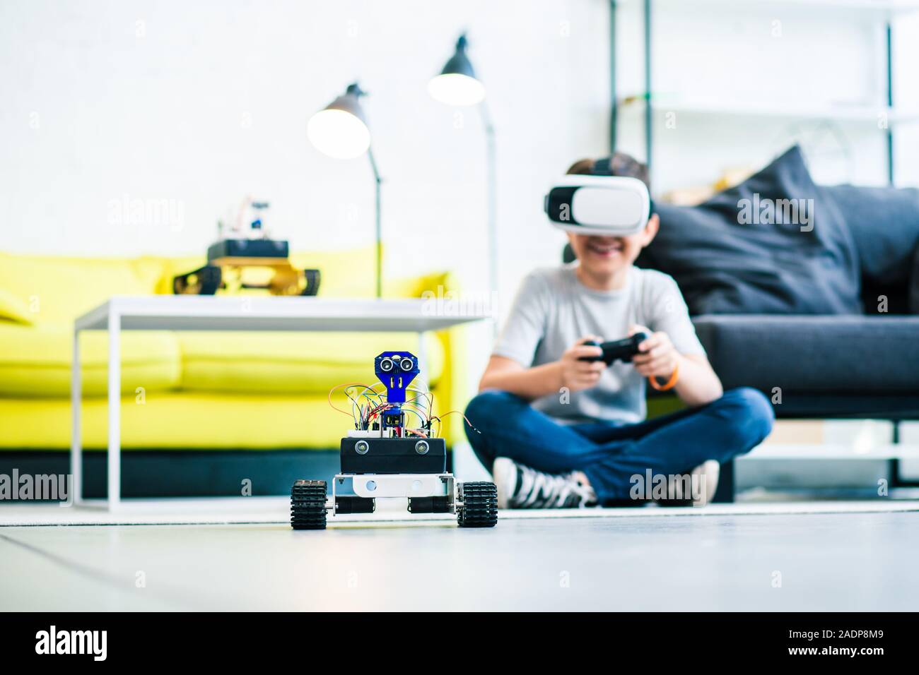 Joyful little boy using a remote control to test his robot Stock Photo ...