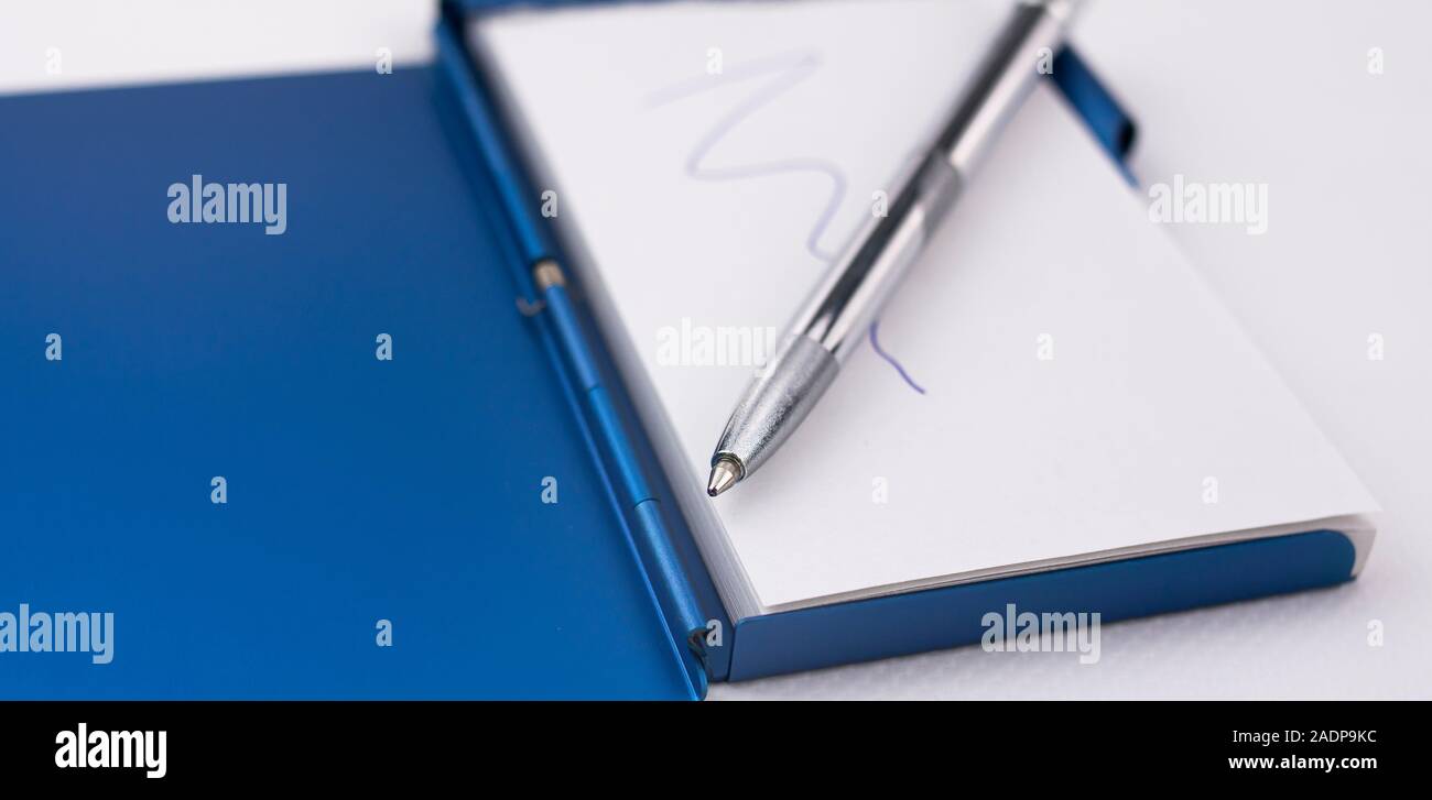 Hold a pen on a notebook to write down ideas and reminders on white ...