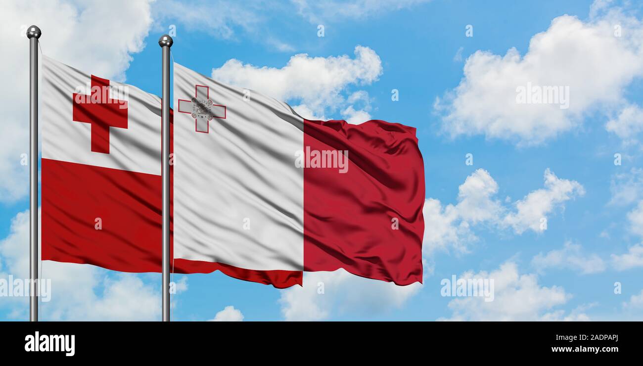 Tonga and Malta flag waving in the wind against white cloudy blue sky ...