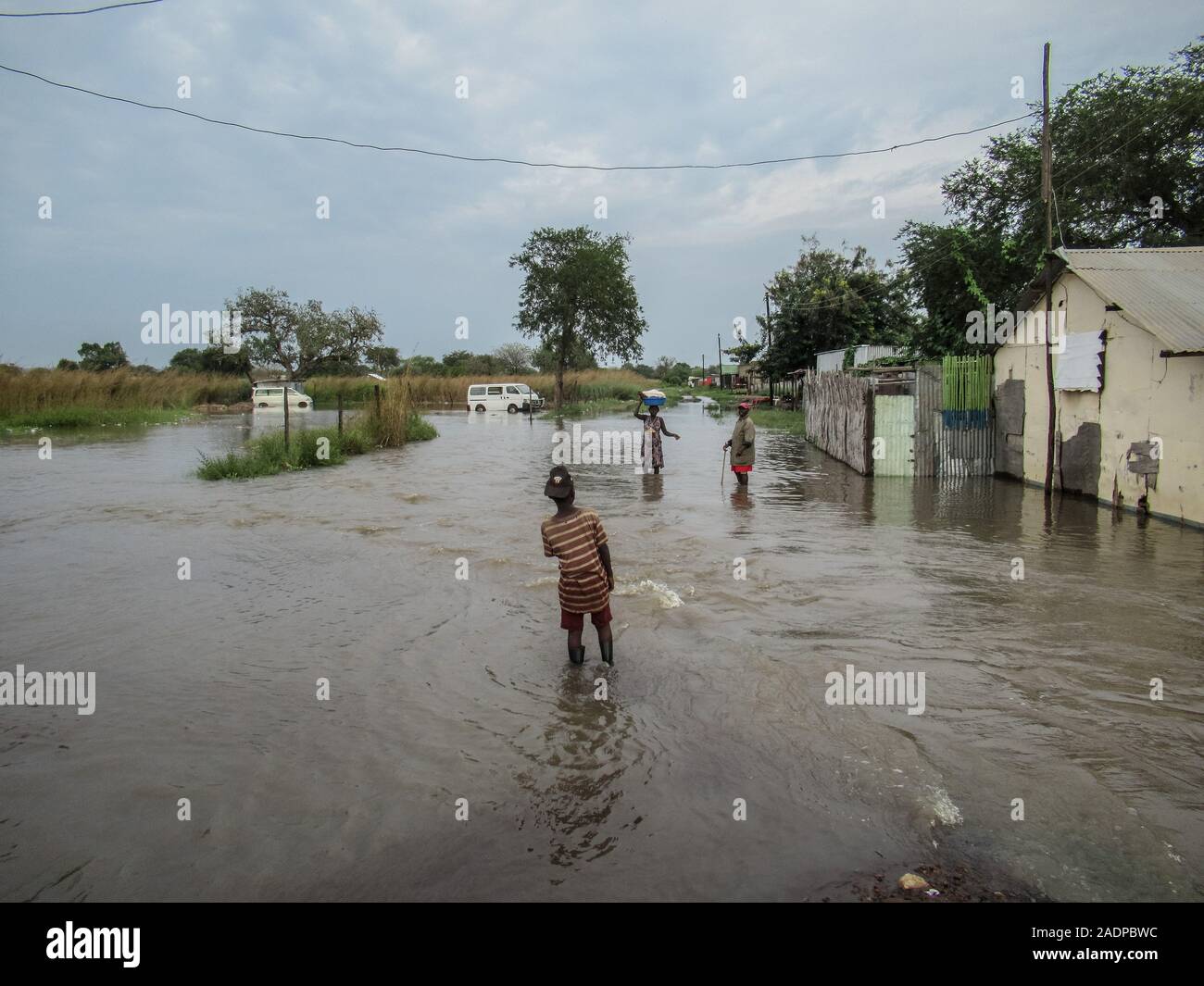 A woman carrying her belongings from a flooded home.Businesses and ...