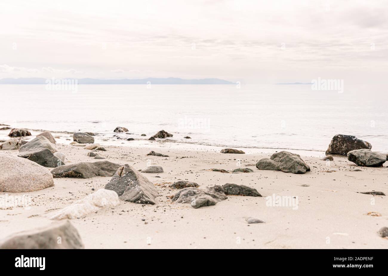 Beach scene with rocks near ocean Stock Photo - Alamy