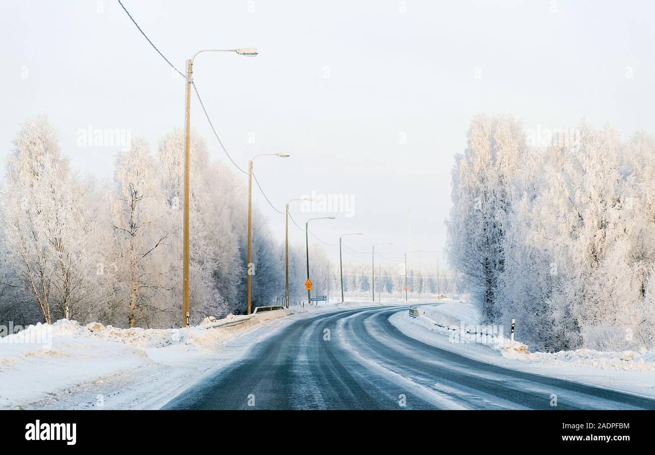 Winter road and a Snowy Forest of Cold Finland reflex Stock Photo - Alamy