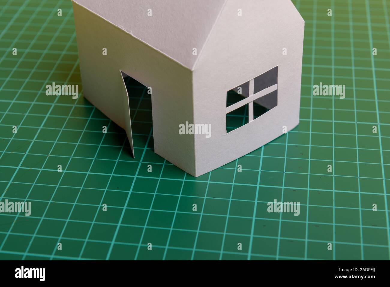 White family paper house over block of flats on yellow background paper ...