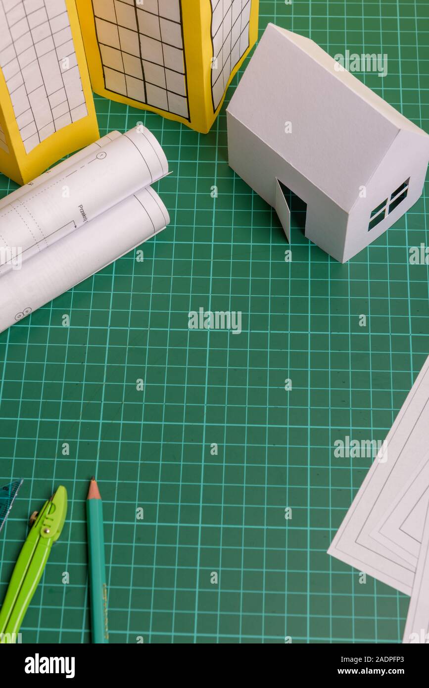 White family paper house over block of flats on yellow background paper ...