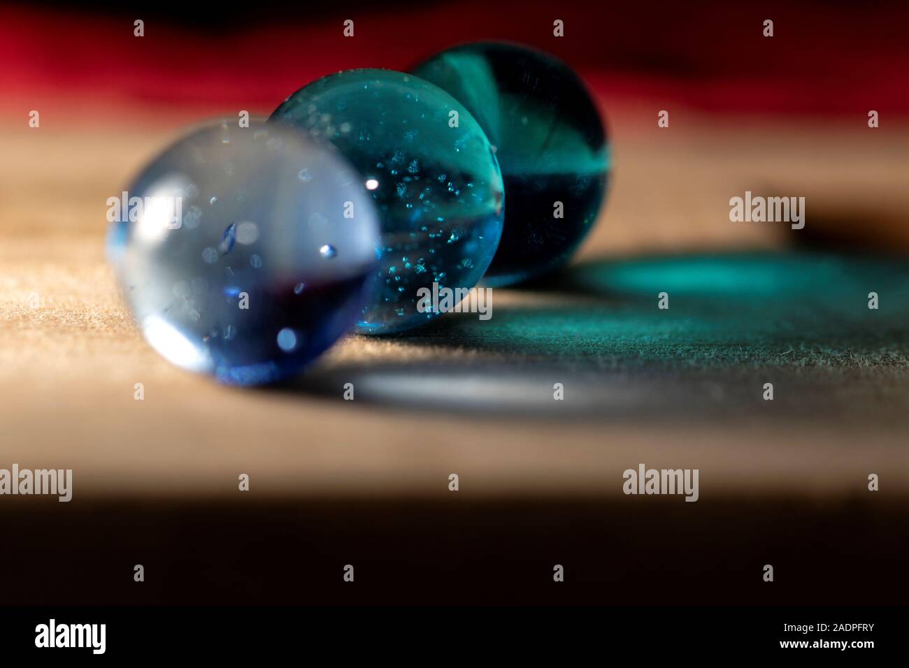 A close up portrait of three colored marbles casting a colored ...