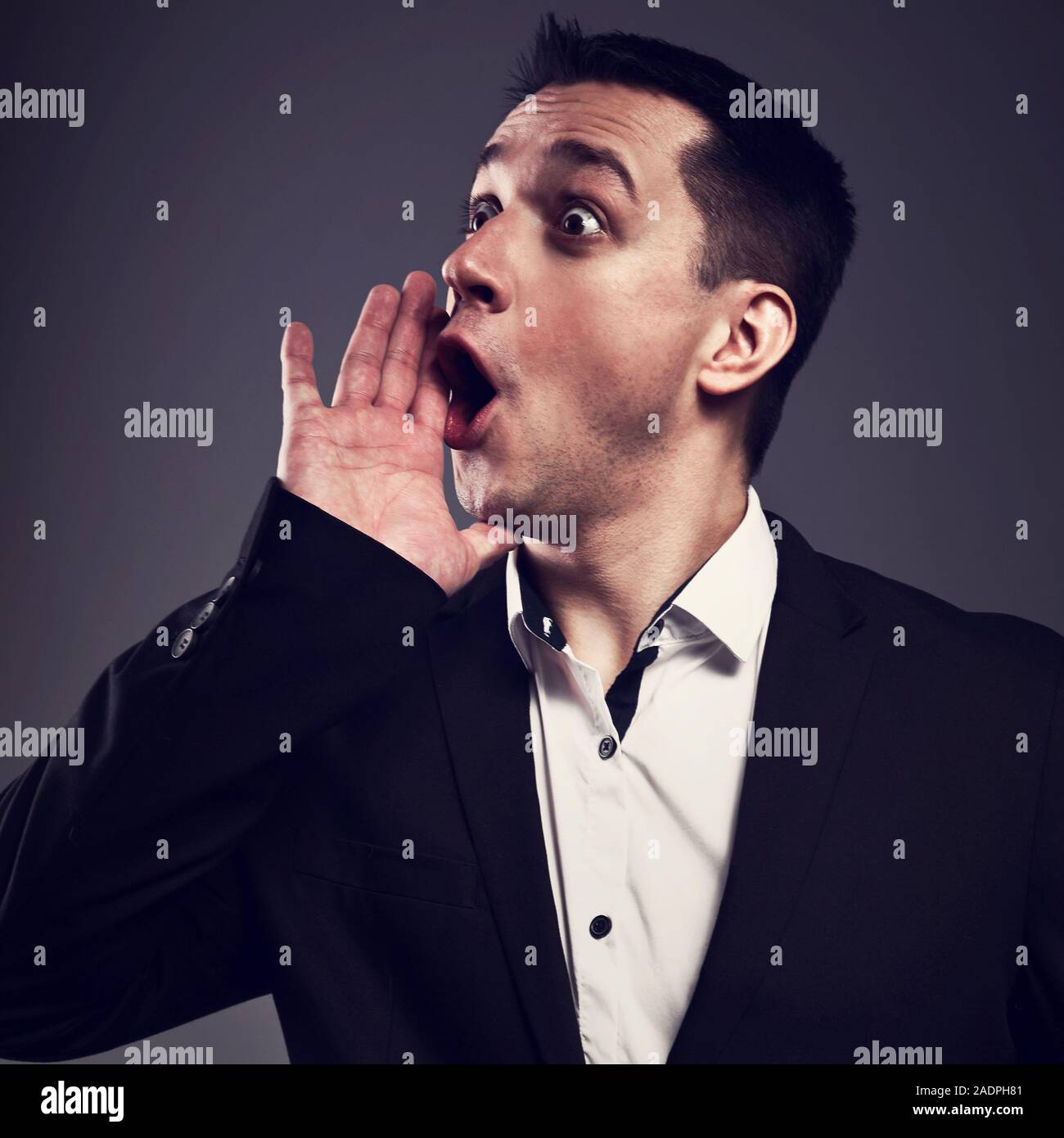 Excited shouting young business man gesturing the hands loudspeaker ...