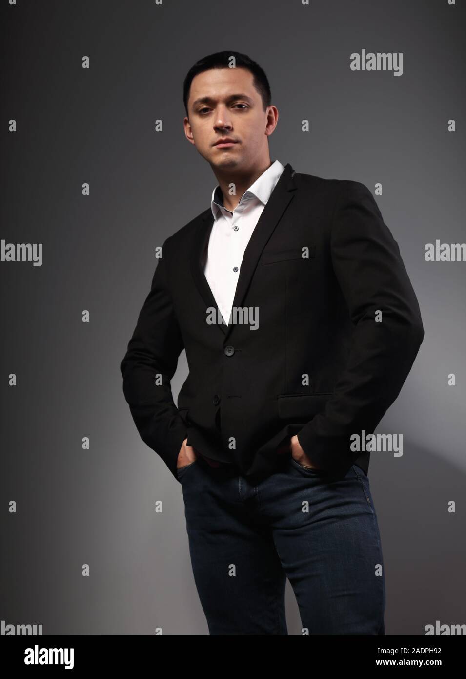 Serious thinking man looking in black suit on grey studio background ...