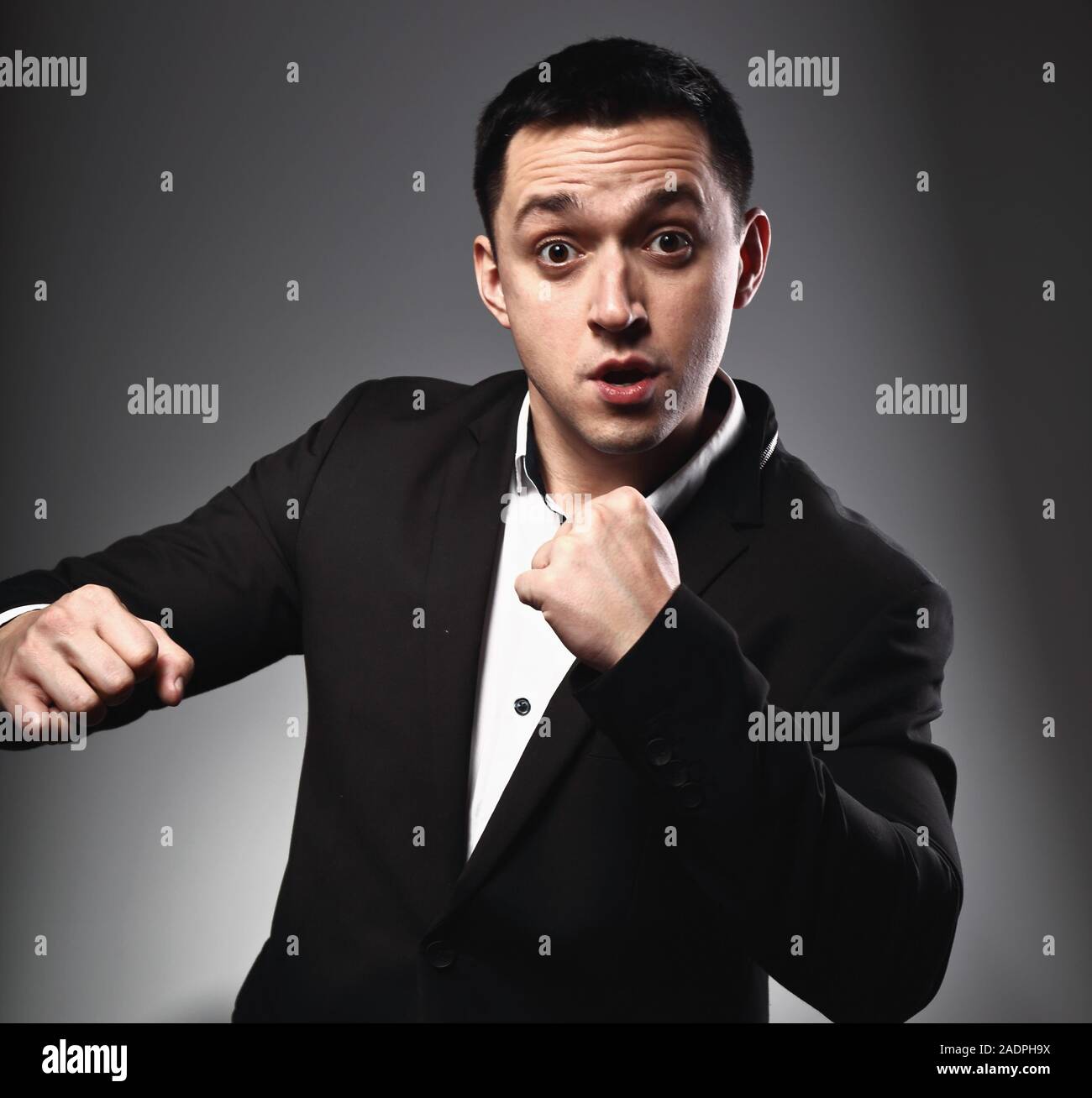 Angry business man fighting and making the hit by the fist on grey ...