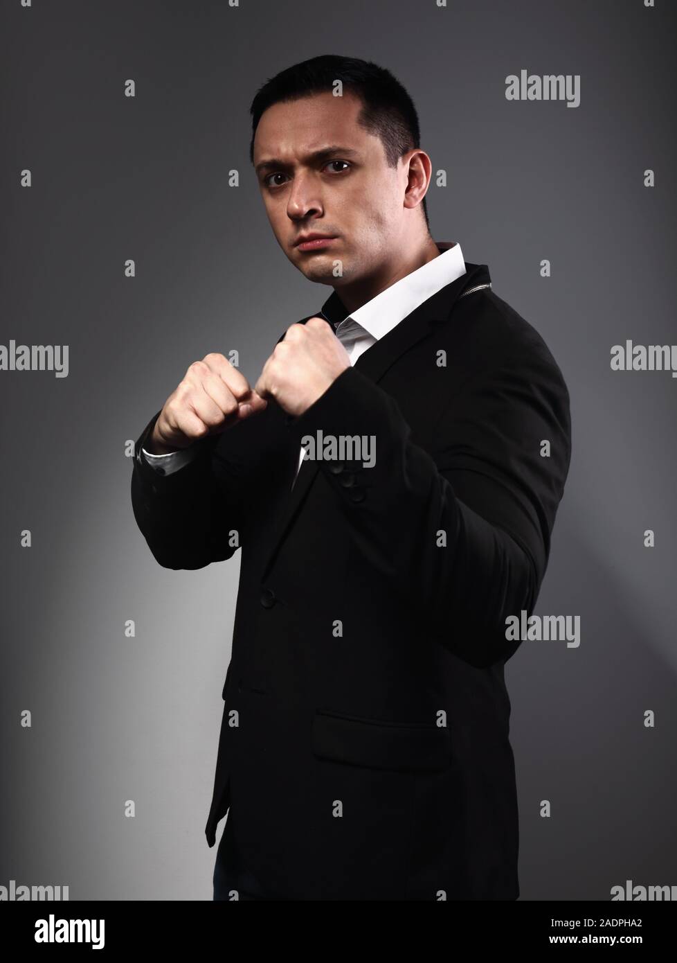 Angry business man fighting and making the hit by the fist on grey ...