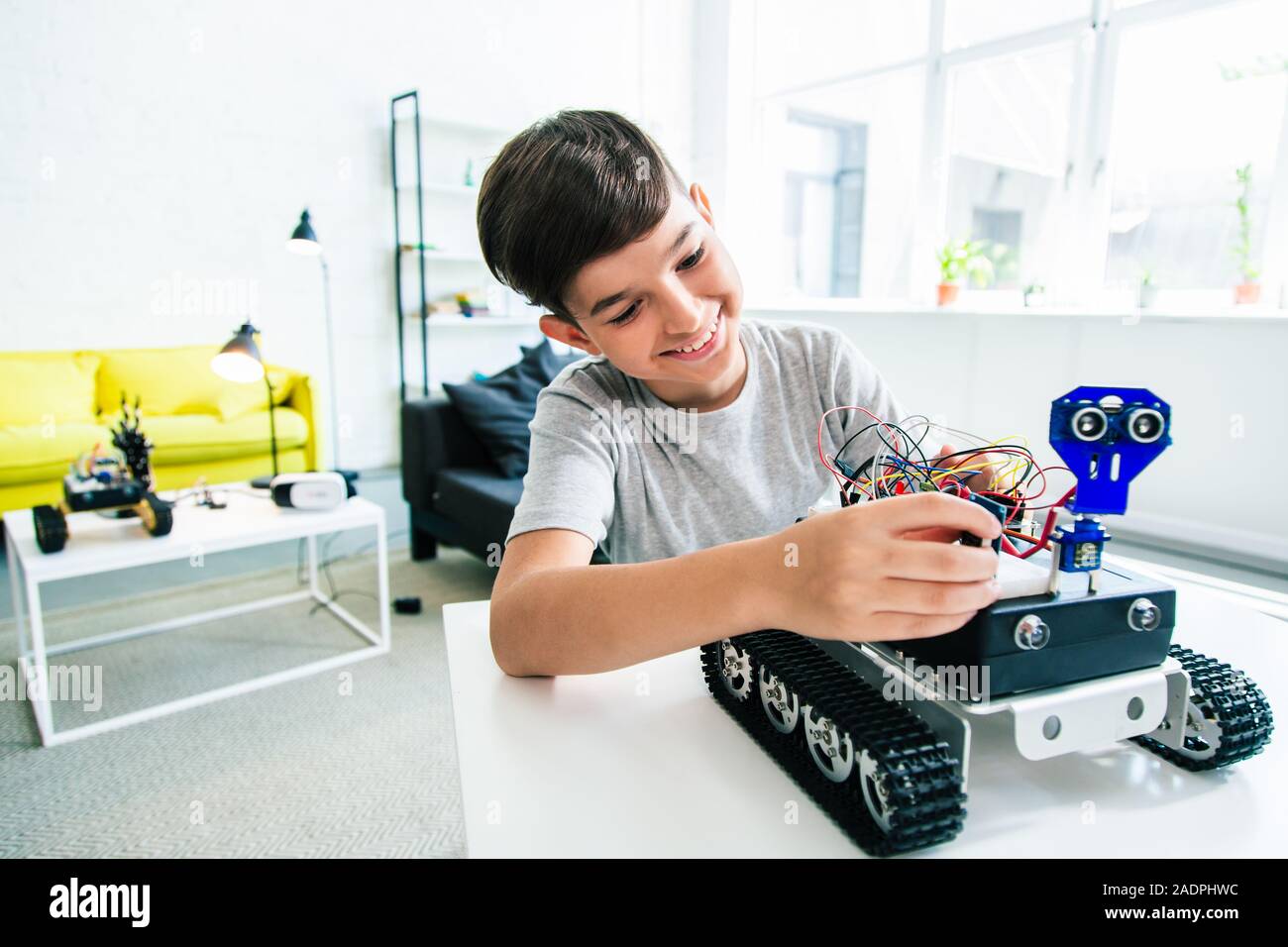 Overjoyed smart boy constructing his robotic device Stock Photo - Alamy