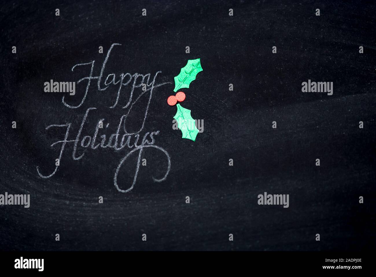 Happy Holidays handwritten in white chalk script on blackboard with ...