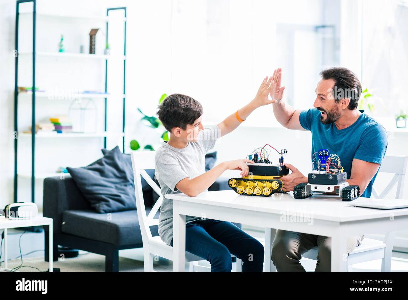 Cheerful father giving high five to his son Stock Photo - Alamy