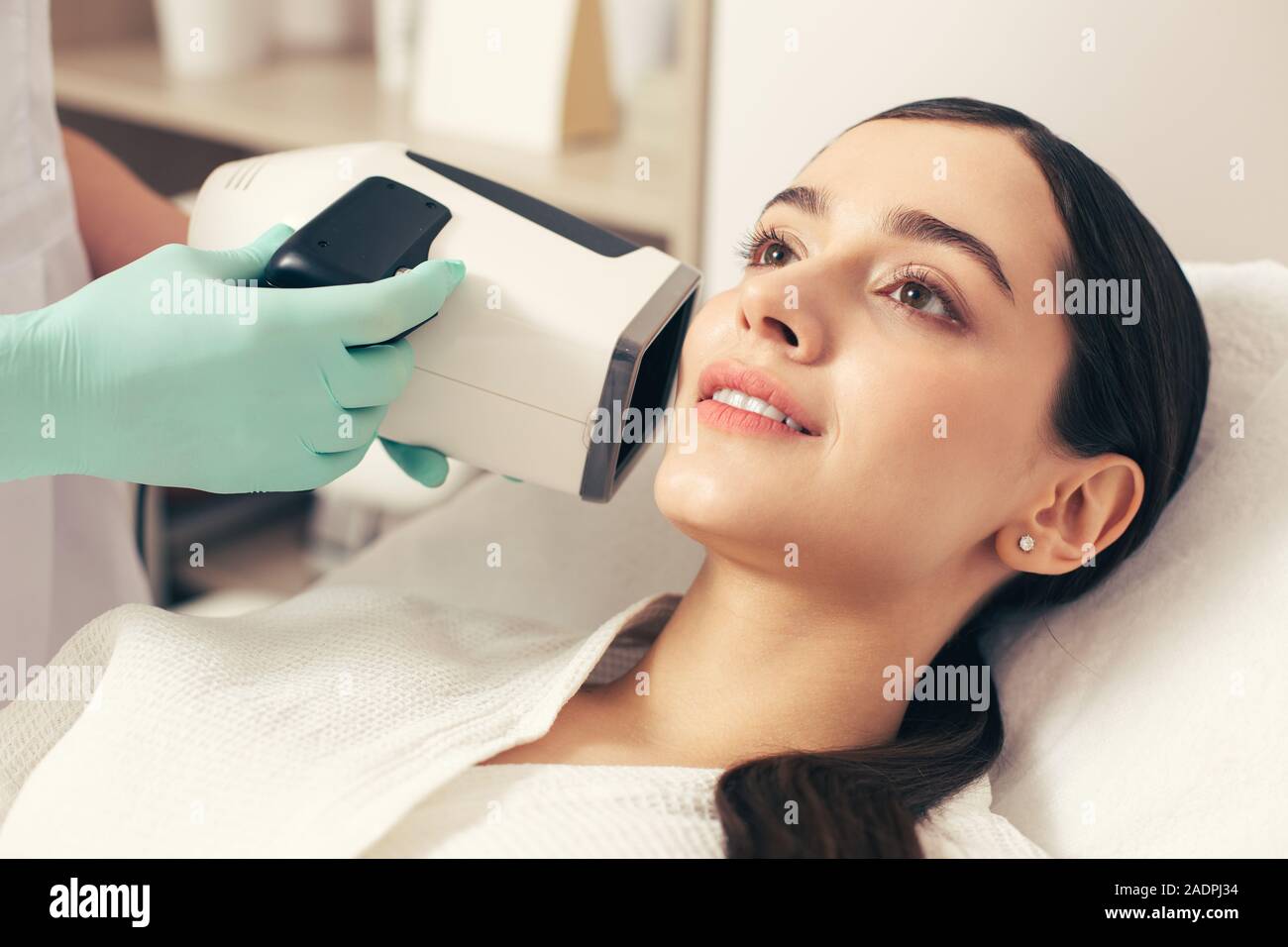 Dark haired woman with skin analysis camera near her cheek Stock Photo ...