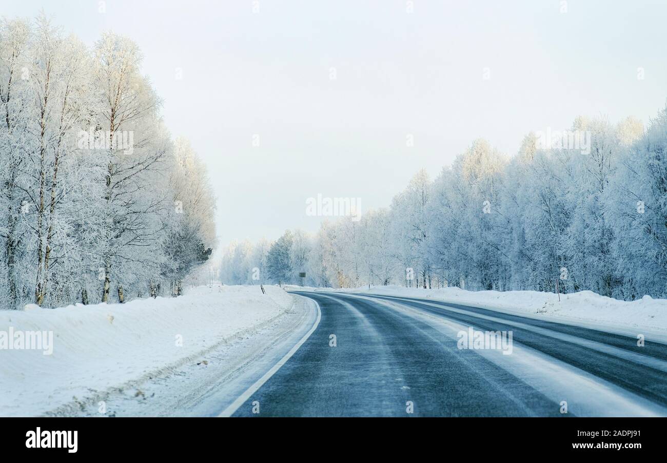 Winter road and a Snowy Forest at Cold Finland reflex Stock Photo - Alamy