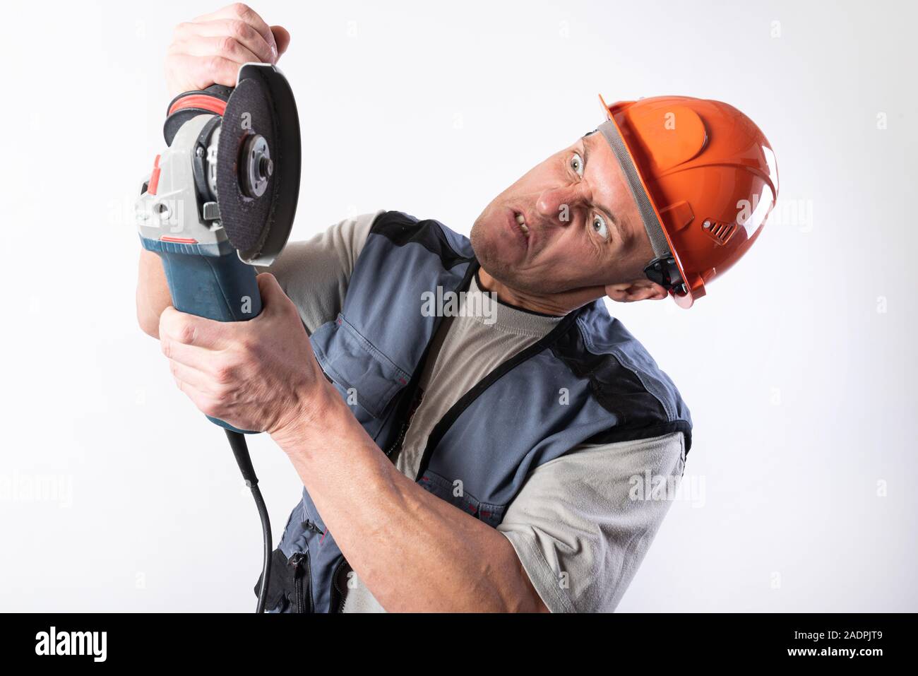 Builder with angle grinder, in a helmet, with a funny expression on his ...