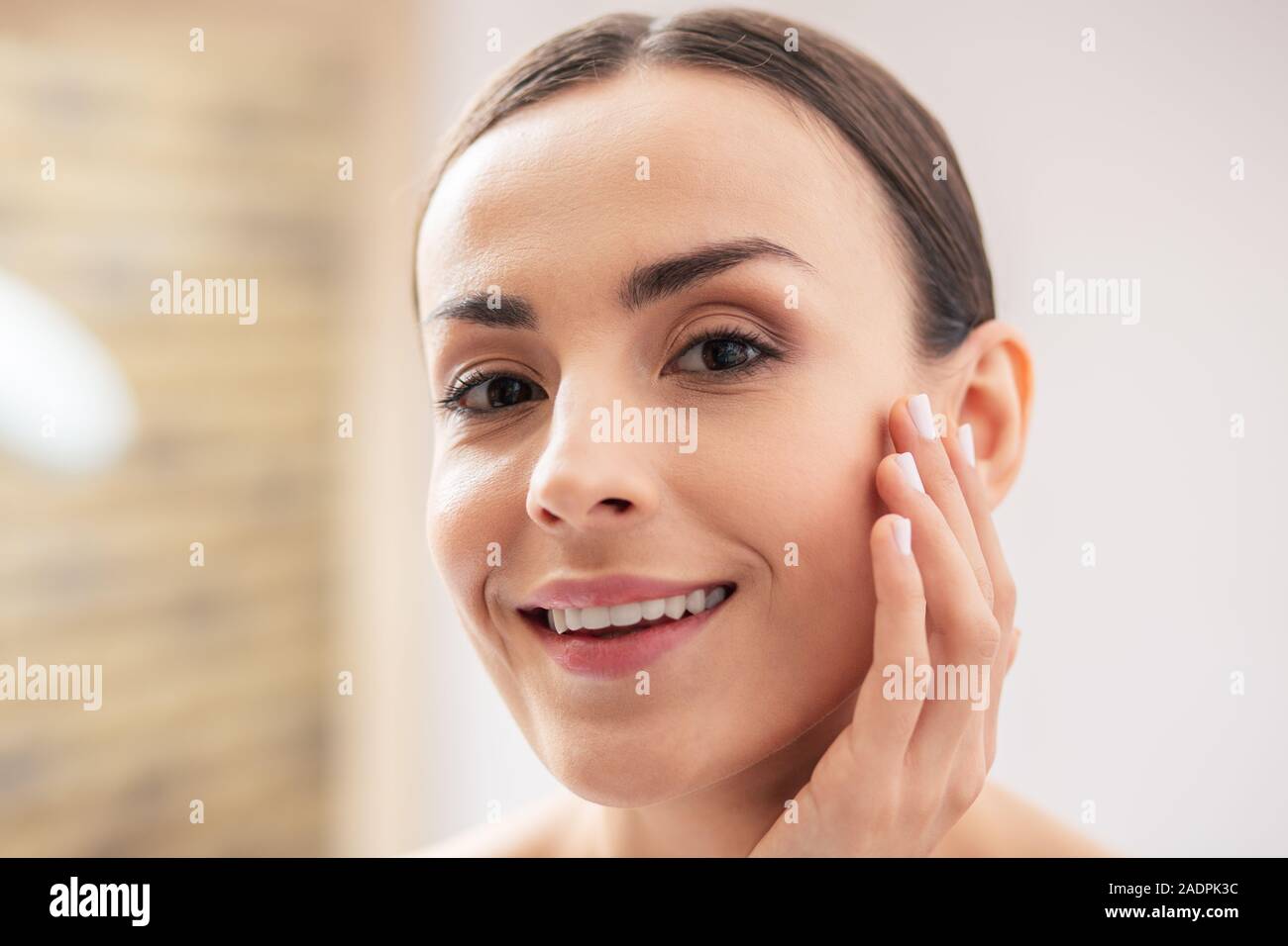 Portrait of happy lady smiling and touching her cheek Stock Photo - Alamy