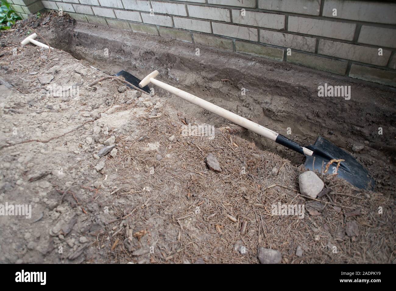 shovel in a ditch for the foundation in the garden by the fence Stock ...