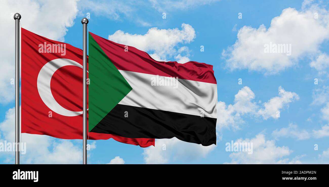 Turkey and Sudan flag waving in the wind against white cloudy blue sky ...