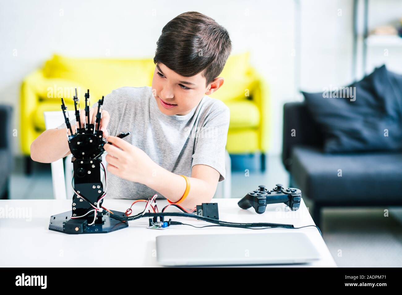 Concentrated young boy constructing his robotic hand at home Stock ...