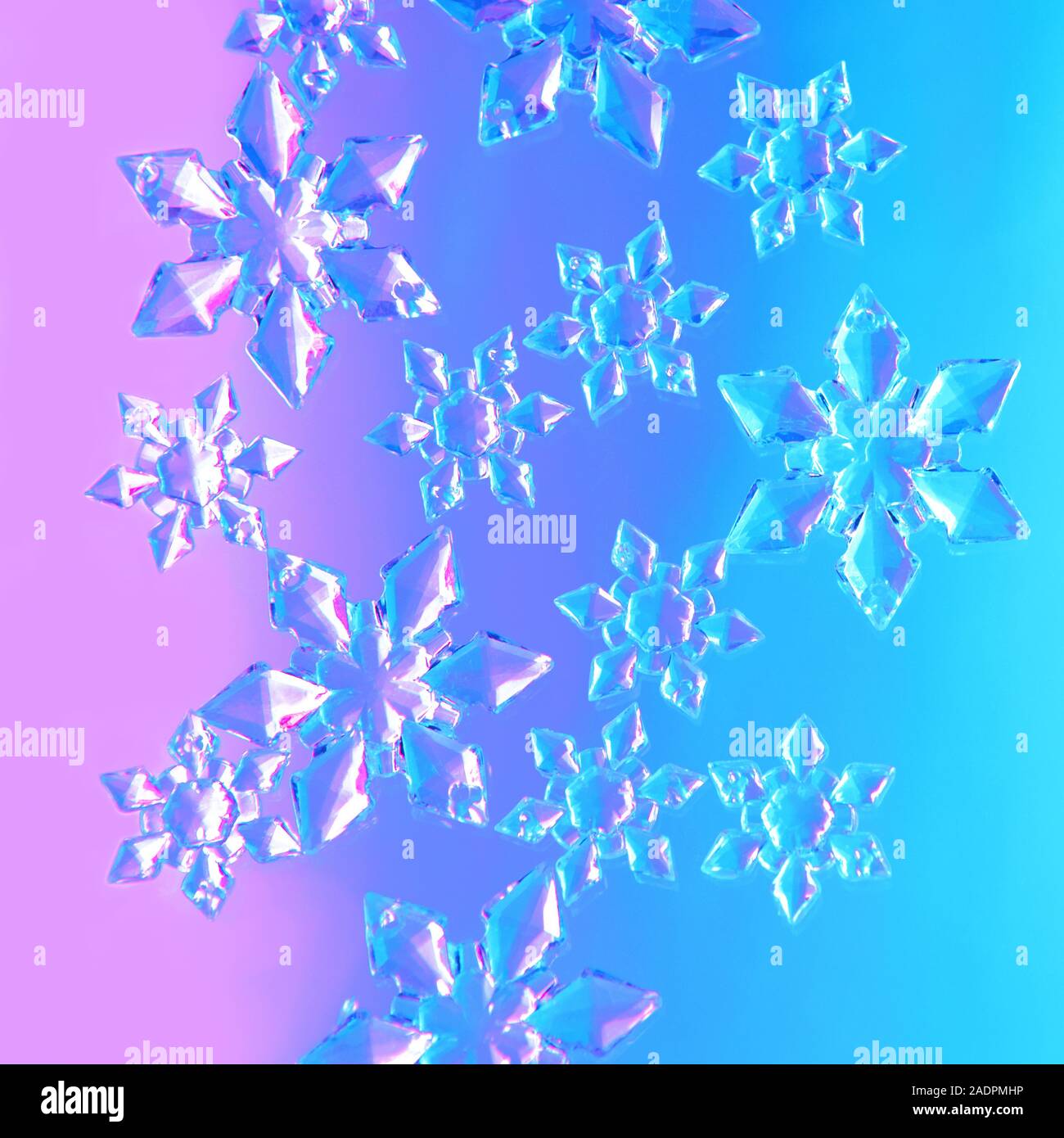 Clear glass snowflake in neon light on gradient purple and blue ...