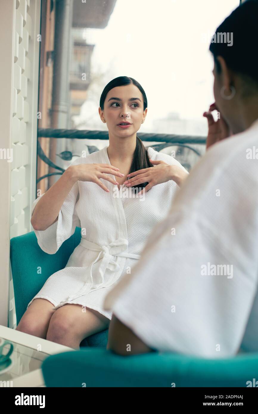 Emotional lady in bathrobe gesturing while talking Stock Photo - Alamy