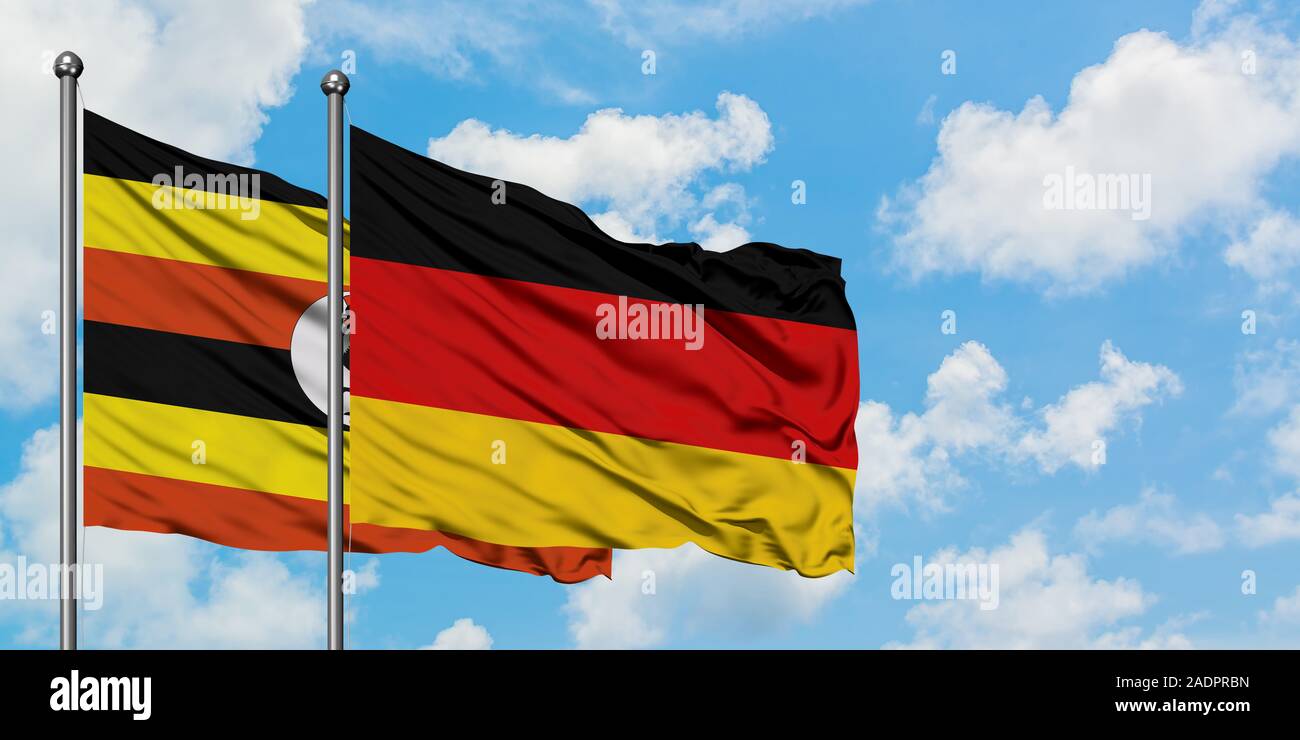 Uganda and Germany flag waving in the wind against white cloudy blue ...