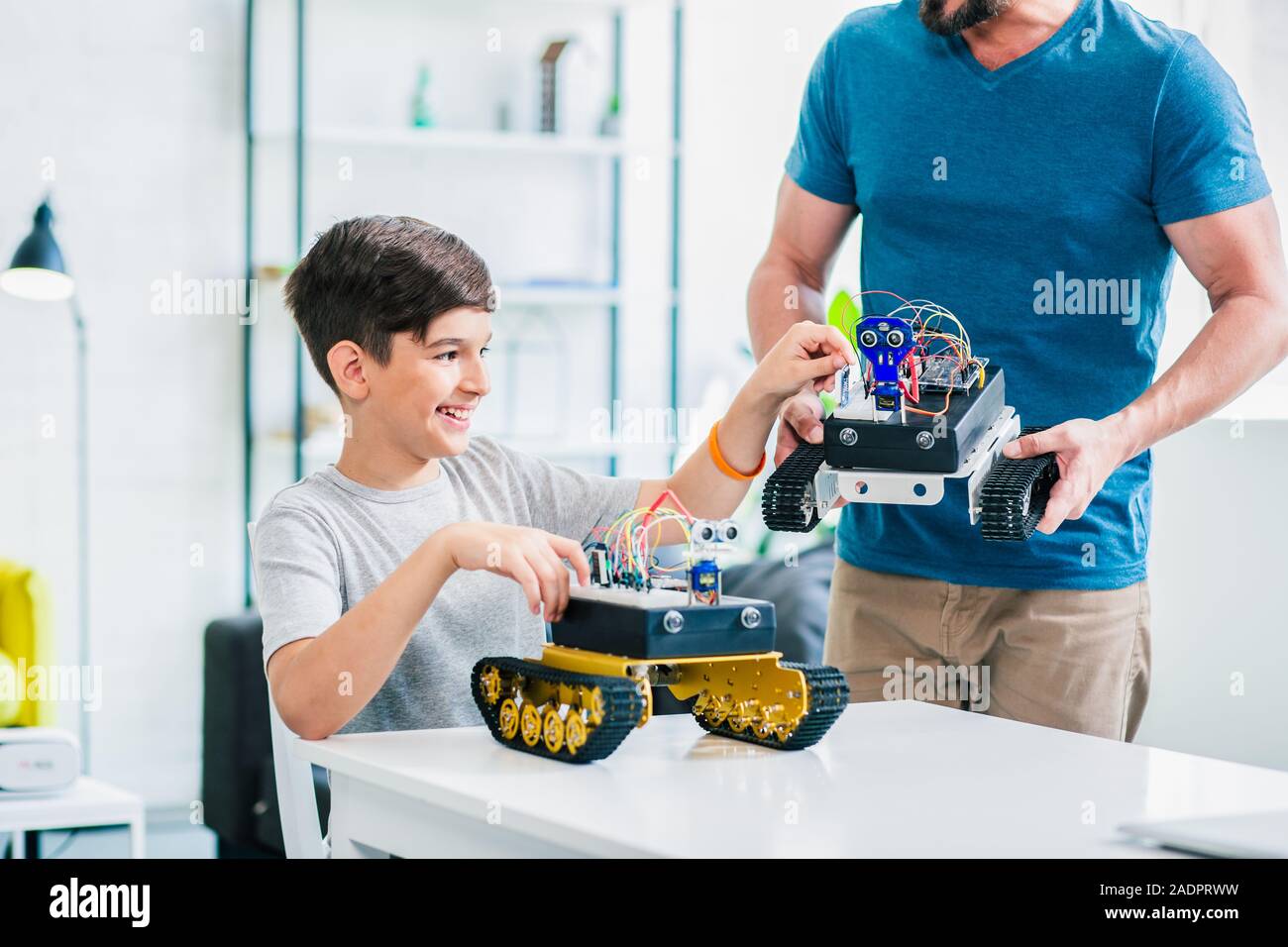 Cheerful smart schoolboy experimenting with robotic devices Stock Photo ...