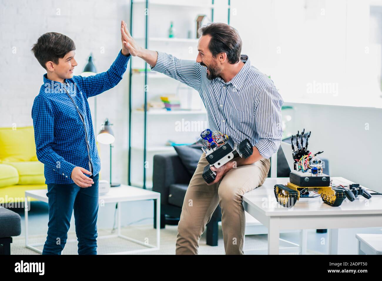 Overjoyed father and son giving high five Stock Photo - Alamy