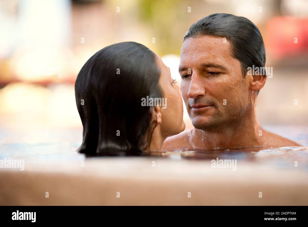 Mid-adult man looking intensely at his girlfriend while standing close ...