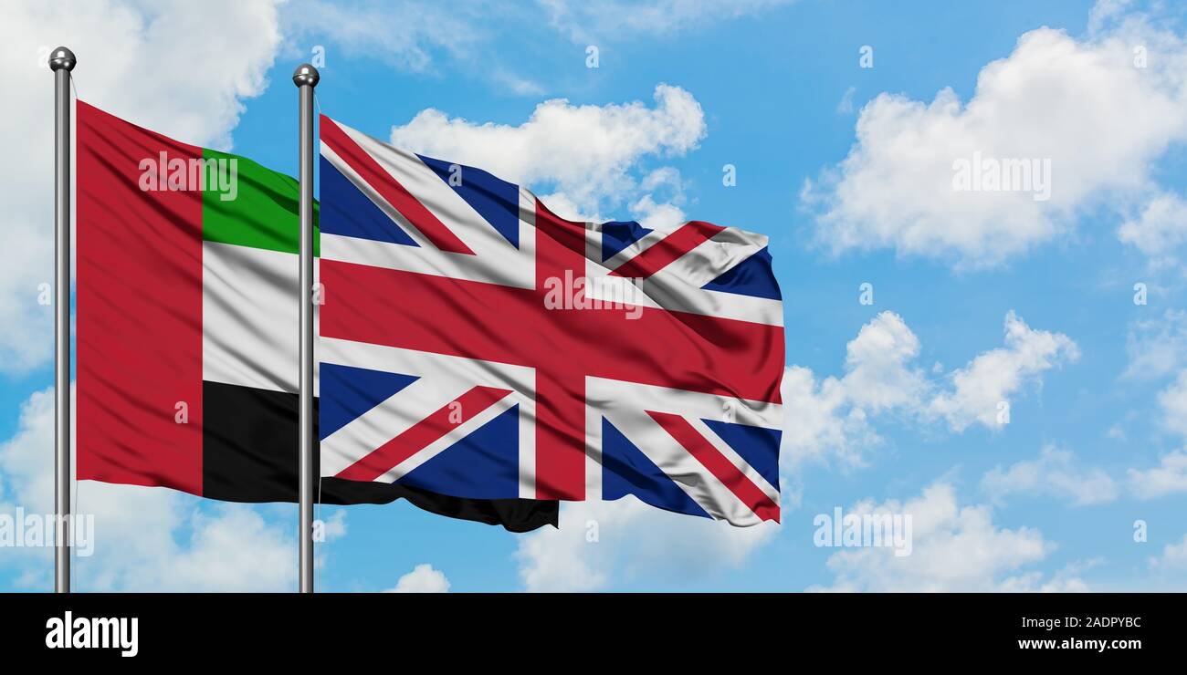 United Arab Emirates and United Kingdom flag waving in the wind against ...