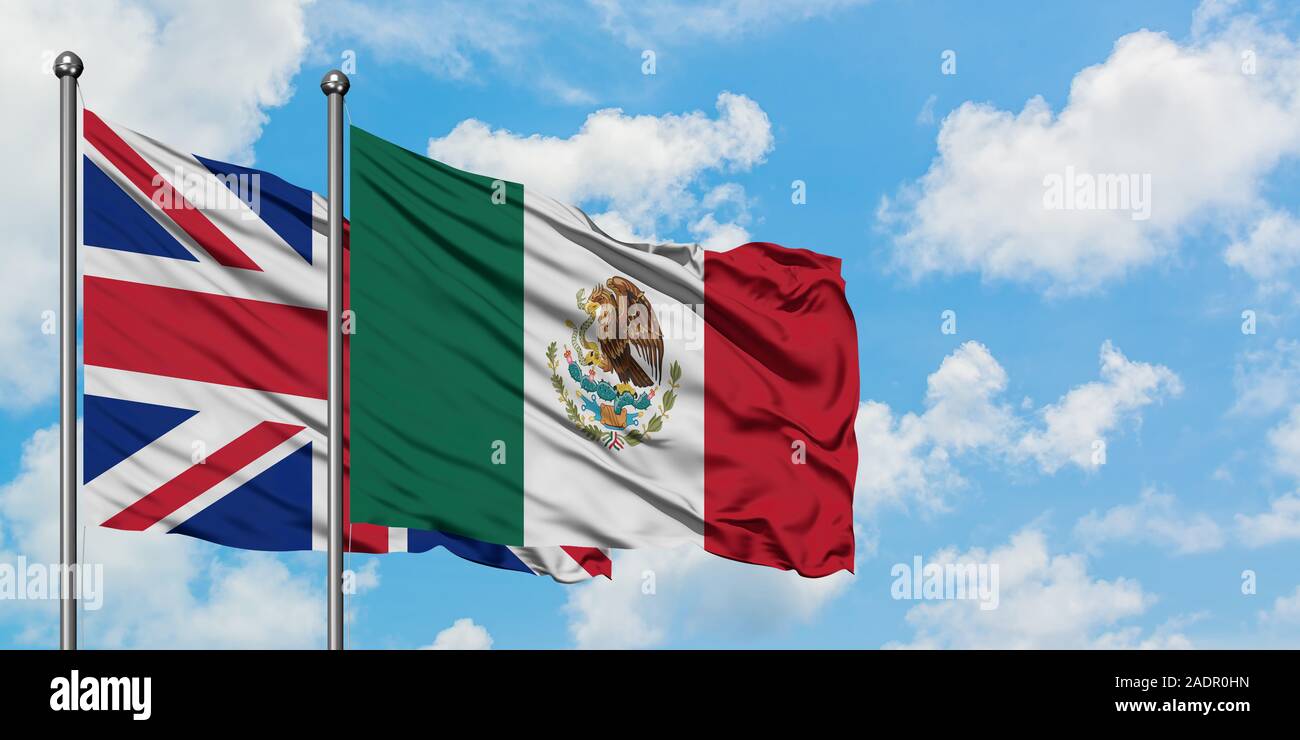 United Kingdom and Mexico flag waving in the wind against white cloudy ...