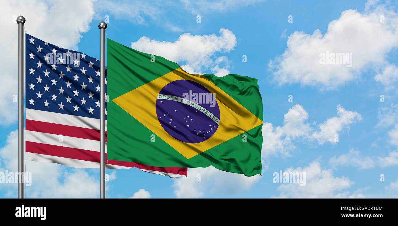 United States and Brazil flag waving in the wind against white cloudy ...