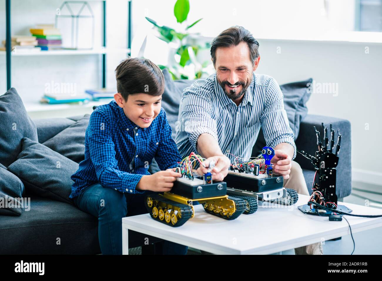 Cheerful father and his son constructing robotic devices Stock Photo ...