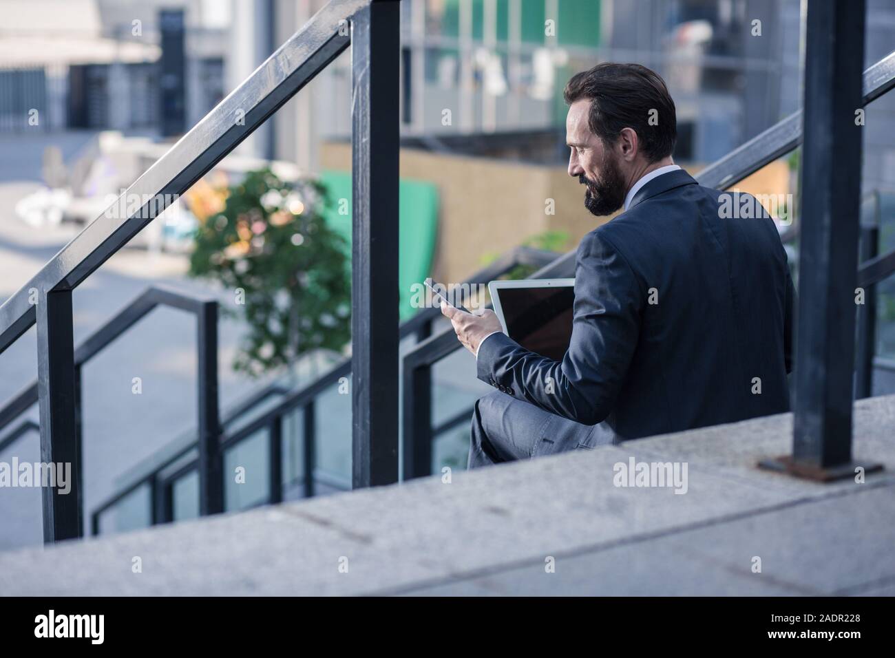 Rear view of a professional businessman using his laptop outdoors Stock ...